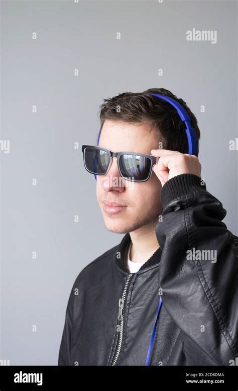 A Stylish Modern Teen In Sunglasses And Headphones Listening To Music