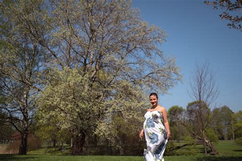 젊은 여행자 임신 한 여자 걷기 달리기 주위를 선회 하 고 꽃 패턴으로 여름 빛 긴 드레스를 입고 꽃 피는 사쿠라 벚꽃 나무 공원에서 그녀의 여가 자유 시간을 즐긴다 개념에