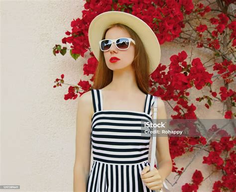 빨간 꽃 배경에 여름 밀짚 모자를 쓰고 있는 아름다운 여성의 초상화 20 29세에 대한 스톡 사진 및 기타 이미지 20 29세 25 29세 개화기 Istock
