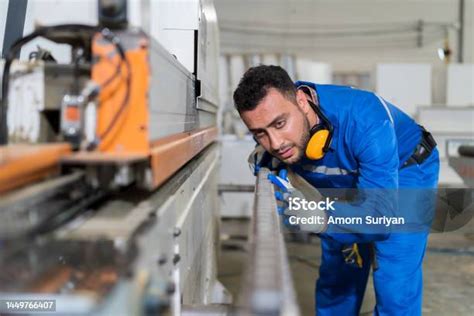 산업 공장에서 컨베이어 벨트 기계를 확인하는 남성 엔지니어 노동자 남성 기술자는 공장에서 안전 장갑과 균일 한 작업 유지 보수 기계를 착용합니다 창고에 대한 스톡 사진 및