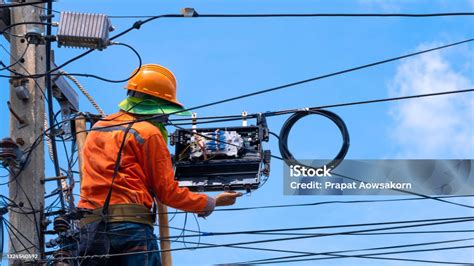 나무 사다리에 기술자는 푸른 하늘에 대한 전신주에 광섬유 및 인터넷 스플리터 상자를 설치하고있다 광섬유의에 대한 스톡 사진 및 기타 이미지 Istock