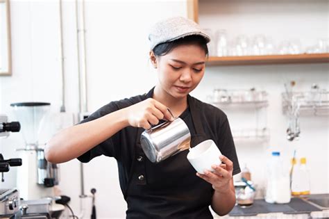 웃는 아시아 바리스타 젊은 여성이 커피 숍의 카운터 바에서 고객의 주문에 따라 뜨거운 검은 커피를 흰색 컵에 붓습니다 가정 주방에 대한 스톡 사진 및 기타 이미지 Istock