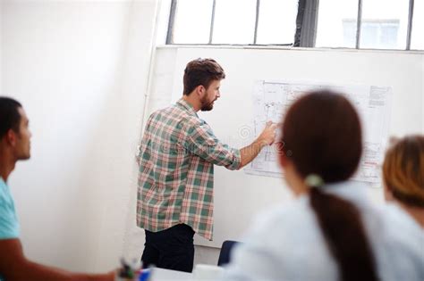 design minds at work rearview shot of a team of designers in a brainstorming session stock