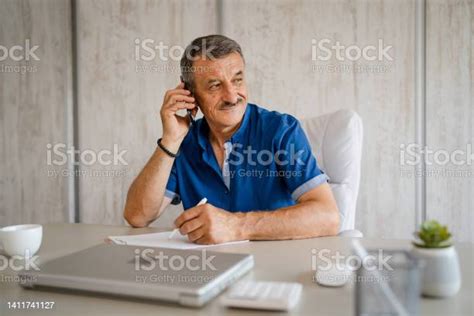 한 남자 고위 기업가 활동적인 백인 남성이 사무실 관리자와 중소기업에서 일하는 책상 테이블에 앉아있는 동안 전화를하는 동안 이야기하는 것은 공간을 복사합니다 60 69세에