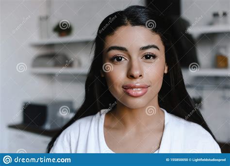 Portrait Of Beautiful Mixed Race Girl In White Robe Looking At Camera