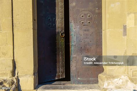 정교회에 오래 된 반 오픈 금속 문 사원의 벽은 노란 석회암으로 만들어졌습니다 열린 문은 성전에 대한 초대장과 같습니다 0명에 대한 스톡 사진 및 기타 이미지 Istock