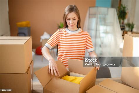 새로운 시작에 대한 기쁨과 기대로 가득 찬 새 아파트에서 판지 상자를 푸는 젊은 여성 가정 생활에 대한 스톡 사진 및 기타 이미지 가정 생활 가정 주부 거실 Istock