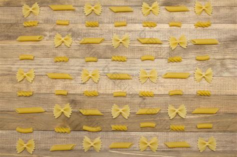 不同形状的意大利面国际象棋顺序放在木头上 包图企业站