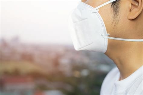 얼굴 위생 마스크 코를 야외에서 착용 하는 사람의 초상화 생태 공기 오염 자동차 환경 및 바이러스 보호 개념 독감 건강 독성 먼지에 대 한 건강 효과의 도시 커버 가솔린에