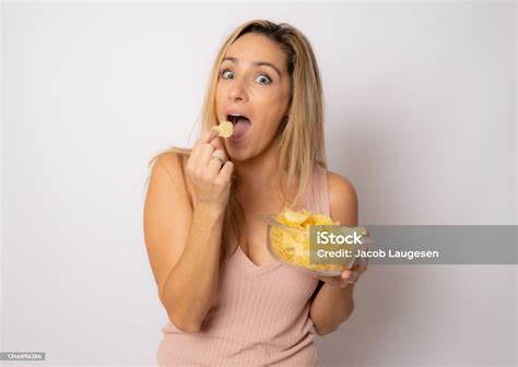 젊은 아름다운 여자는 매우 행복 흰색 배경 위에 서 칩 감자를 먹고 먹기에 대한 스톡 사진 및 기타 이미지 먹기 여자 명랑한 Istock