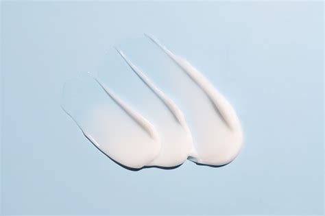 파란색 배경에 흰색 크림의 질감입니다 모이스처 라이저의 얼룩이 닫힙니다 로션 견본 뷰티 스킨 케어 제품 얼룩 얼룩 파란색 배경에