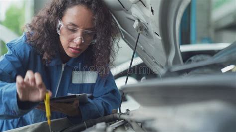A Woman Auto Mechanic Female Auto Mechanic Uses A Special Tablet Computer To Diagnose Faults
