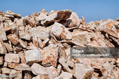 화강암은 갈색 건설 및 여름 시간에 푸른 하늘 아래 더미에 쌓여 바위 바위의 큰 더미 채 석 장에서 석회석의 큰 더미입니다 자갈