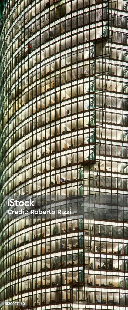 밤에는 완전히 조명되는 고층 빌딩의 외관 조명이 켜진 창문 패턴이 있는 고층 건물 외관 다국적 기업 또는 사무실 본사가 비즈니스 빌딩을 비추기 위해 전기를 낭비하는 경우