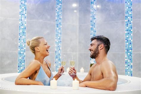 Premium Photo Couple Sitting In The Hot Tub At The Spa Center And Having A Glass Of Champagne