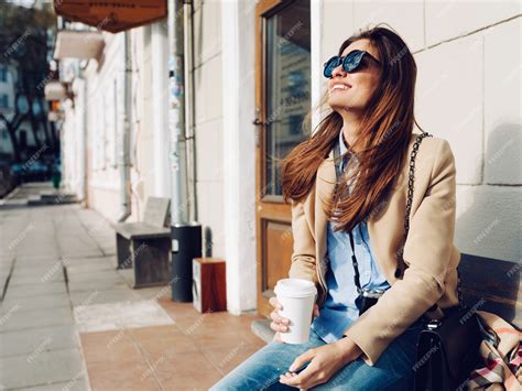 Premium Photo Girl Sitting On The Bench And Drinking Coffee