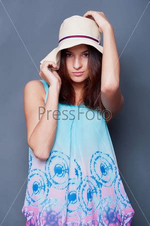 Фотография на тему Женщина придерживает шляпу на голове, синий фон ...