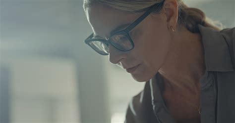 사무실에서 일하는 동안 안경을 쓴 진지한 사업가 그녀의 사무실에서 바쁜 전문 여성 그녀의 신생 기업에서 비즈니스 성공을 달성하기 위해 열심히 노력하는 성숙한 여성 기업가