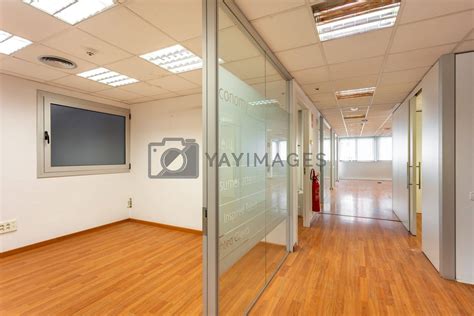 Glass Partition Enclosing Empty Office Room From Corridor With Window
