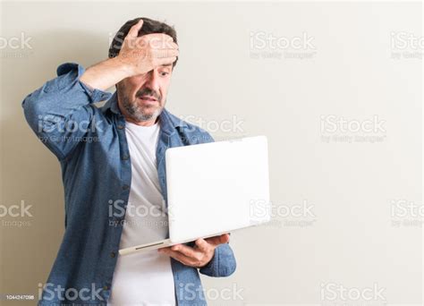 수석 남자 머리에 손으로 압박 하는 랩톱 컴퓨터를 사용 하 여 충격 수치심과 깜짝 얼굴로 분노와 좌절 두려워 하 고 실수에 대