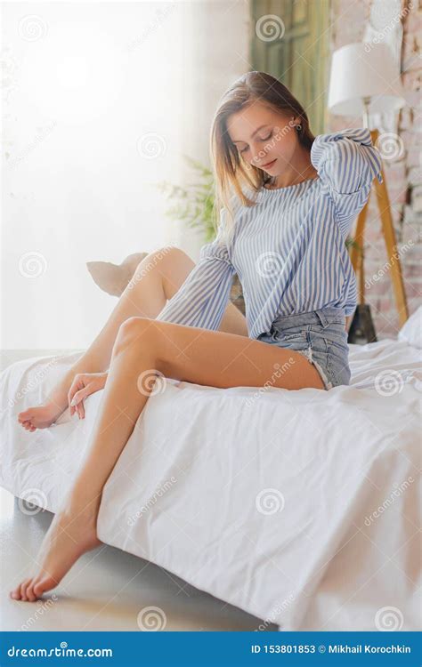 Young Cute Girl Sitting On Bed Beauty Comfort And Relaxation Stock