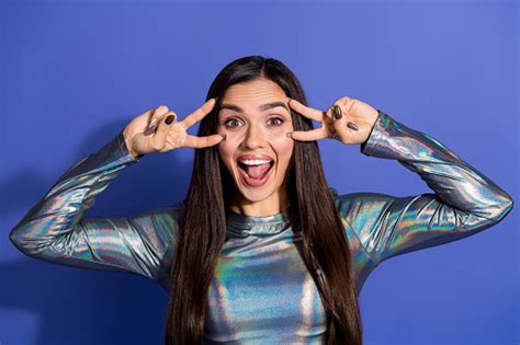 광택 있는 옷을 입고 보라색 배경에 미소를 짓고 손으로 장난기 넘치는 평화 제스처를 취하는 젊은 여자 35 39세에 대한 스톡 사진 및 기타 이미지 Istock