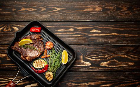 그릴 팬에 스테이크 다진 된 야채 레몬 고추 마늘과 어두운 소박한 배경에 조미료 옆 고기에 대한 스톡 사진 및 기타 이미지