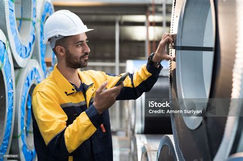 알루미늄 소재 창고에서 아연 도금 또는 금속 시트의 품질 롤을 검사하는 남성 공장 직원 공장의 제조 과정에서 원료 창고에서 일하는 남성 근로자 25 29세에 대한 스톡 사진