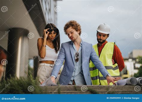 Architects And Engineers Discussing Blueprints Collaborating On Construction Planning Outdoors