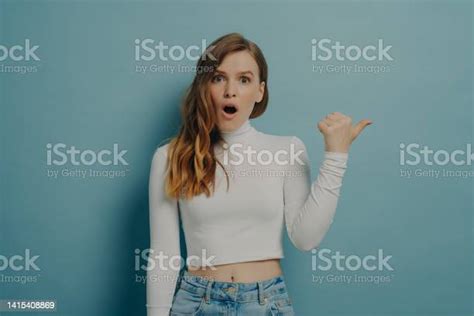 놀랍게도 놀랄 젊은 갈색 머리 여자 가리키는 와 엄지 손가락 옆으로 에 복사 공간 30 34세에 대한 스톡 사진 및 기타 이미지 30 34세 가리키기 광고 Istock