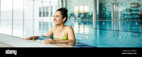A Young Brunette Woman In A Vibrant Green Bikini Relaxes In An Indoor