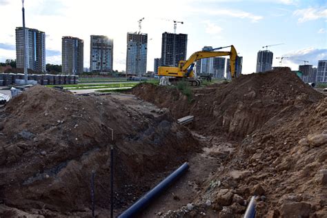 굴삭기는 건설 현장에서 참호를 파는다 외부 하수도 파이프를 놓는 트렌치 다층 건물을 위한 하수 배수 시스템 건설 기계류에 대한