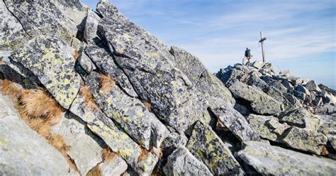 가을에 산에서 배낭 하이킹을 하고 십자가 옆에서 쉬고 있는 성숙한 남자 사진 Unsplash의 자연 이미지