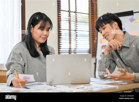 Professional Millennial Asian Male And Female Designers Are Working Together Discussing And