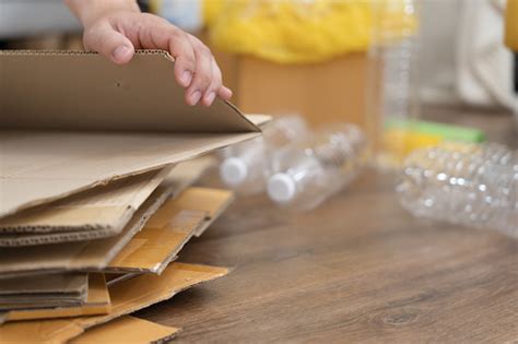 가정 재활용 에코 제로 폐기물 개념 재활용 종이 상자를 사용하는 남자 재활용 가능한 원료로 만든 갈색 판지 상자 친환경 포장을