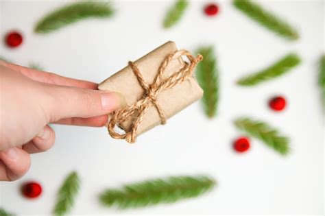 에코 선물을 들고 손을 디포커스하십시오 흰색 전나무 배경 선물 상자를 여는 여자 손 크리스마스 새해 생일 개념 배너 복사 공간