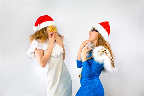 스튜디오의 파스텔 빛 배경에 고립 된 포즈를 취한 크리스마스 모자에 젊은 산타 커플 친구 소녀충격 새해 복 분 2020 축 하 휴일 개념입니다 복사 공간을 모의합니다 12