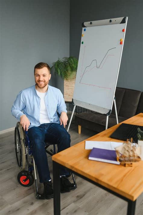 Handicapped Businessman Sitting On Wheelchair And Using Computer In