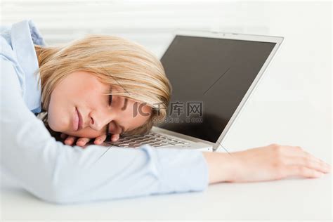 可爱的金发女人睡在她的笔记本上拿着一杯咖啡高清摄影大图 千库网