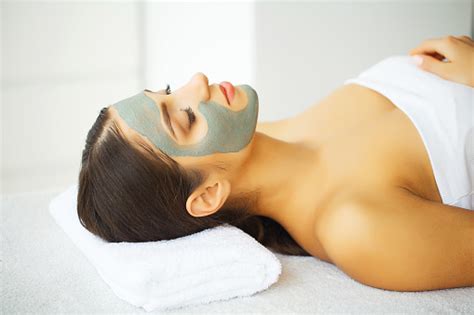 얼굴에 화장품 마스크와 아름 다운 여자입니다 여자는 흰색 배경에 대해 스파 살롱에서 치료를 가져옵니다 수 제 얼굴에 대 한