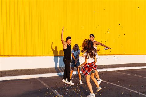 아름 다운 멋진 젊은 점프와 함께 색종이 노란색 배경에 영의 그룹 사람들이 축 하 하 고 재미 여름 분위기 장소 도시에서 산책 친구 라이프 스타일 주차장에서 파티 대학교에