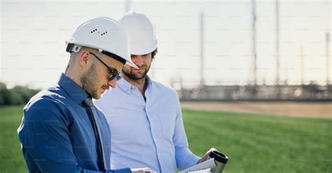 안전모를 쓴 두 명의 젊은 엔지니어가 정유 공장 옆에 서서 문제를 논의하고 있습니다 공간을 복사합니다 사진 Unsplash의 사업 이미지