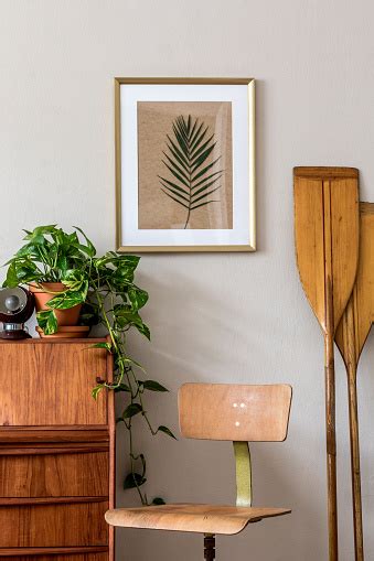 나무 복고풍 Commode와 의자 식물 패들 및 우아한 개인 액세서리와 거실의 세련되고 빈티지 인테리어 디자인 벽에 포스터 프레임을 조롱 템플릿 홈 장식 0명에 대한 스톡