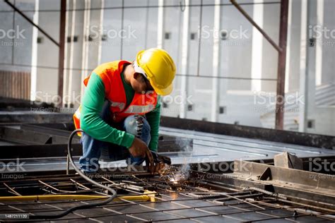 산업 공장에서 일하는 손으로 기계 용접 철을 사용하는 젊은 아시아 노동자 용접공 또는 노동 용접 조인트 강철 반짝임 직업 기술자