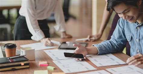 젊은 전문 Ui 그래픽 디자이너 팀이 스마트폰 템플릿으로 함께 토론하는 클로즈업 뷰 사진 Unsplash의 안드로이드 앱 개발 이미지