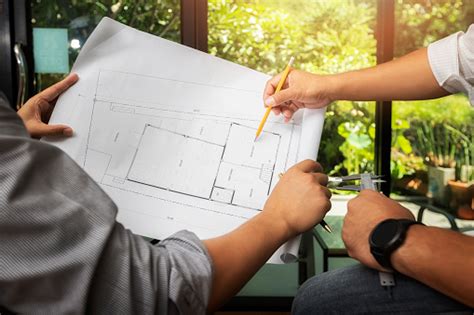 사무실에서 함께 일하는 건축가의 자신감 있는 팀 그들은 책상에서 새로운 시작 프로젝트에 대해 논의합니다 건축가 건축가와 사무실 프로젝트 건축 개념에 대해 논의하다 2명에