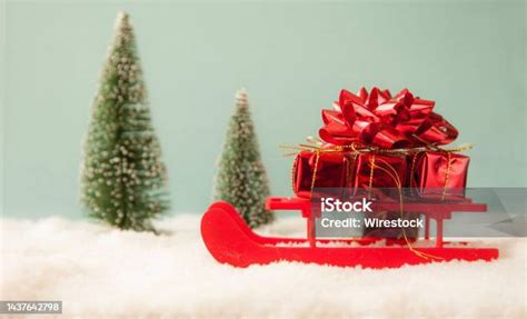 크리스마스 트리 근처에서 선물을 들고 있는 장난감 썰매의 설정에 대한 얕은 초점 근접 촬영 겨우살이과에 대한 스톡 사진 및 기타