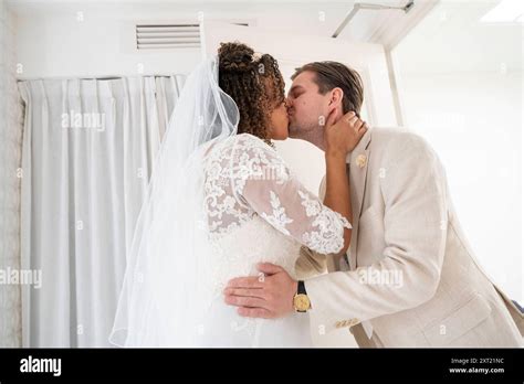 Bride And Groom Share A Passionate Kiss On Their Wedding Day With The Groom In A Beige Suit And