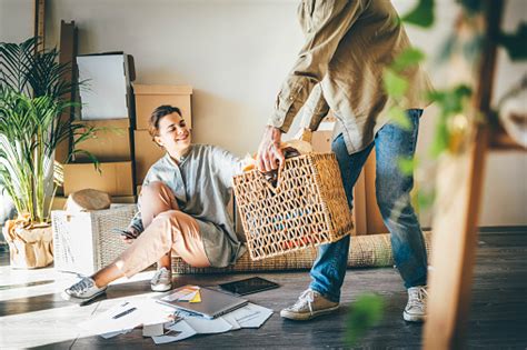 행복한 남자와 캐주얼 옷을 입고 여자의 즐거운 젊은 가족은 새로운 빛 아파트의 큰 방에 다른 소지품 상자를 운반 2명에 대한 스톡 사진 및 기타 이미지 Istock