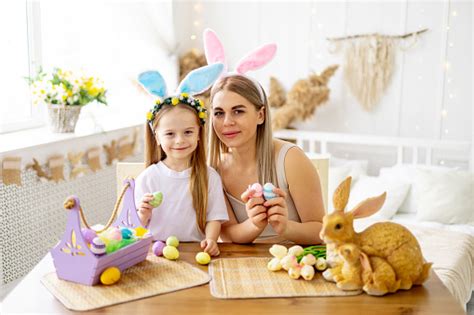 부활절 머리에 토끼 귀를 가진 어린 딸을 둔 어머니는 계란을 색칠하고 놀고 라이프 스타일 부활절을 위해 아이와 함께 행복한 가정을 준비하여 휴가를 준비하고 있습니다 2 3